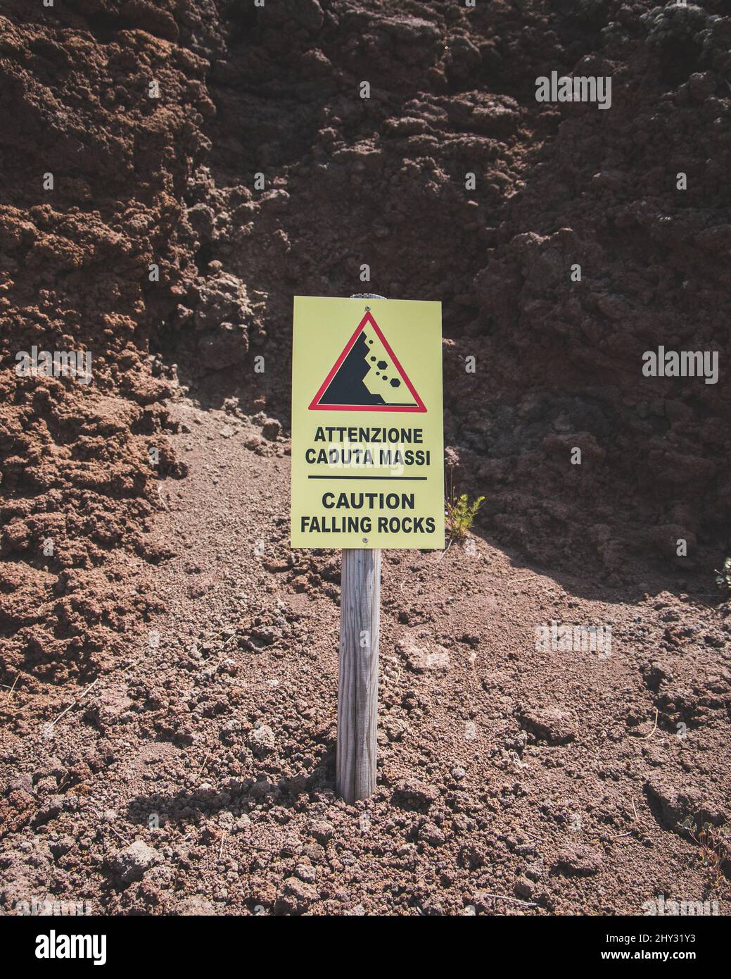 Vertical shot of a signboard of falling rocks stuck in the land Stock ...