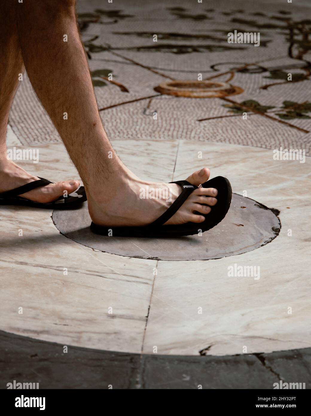Vertical shot of feet with flip-flops walking on a mosaic floor Stock ...