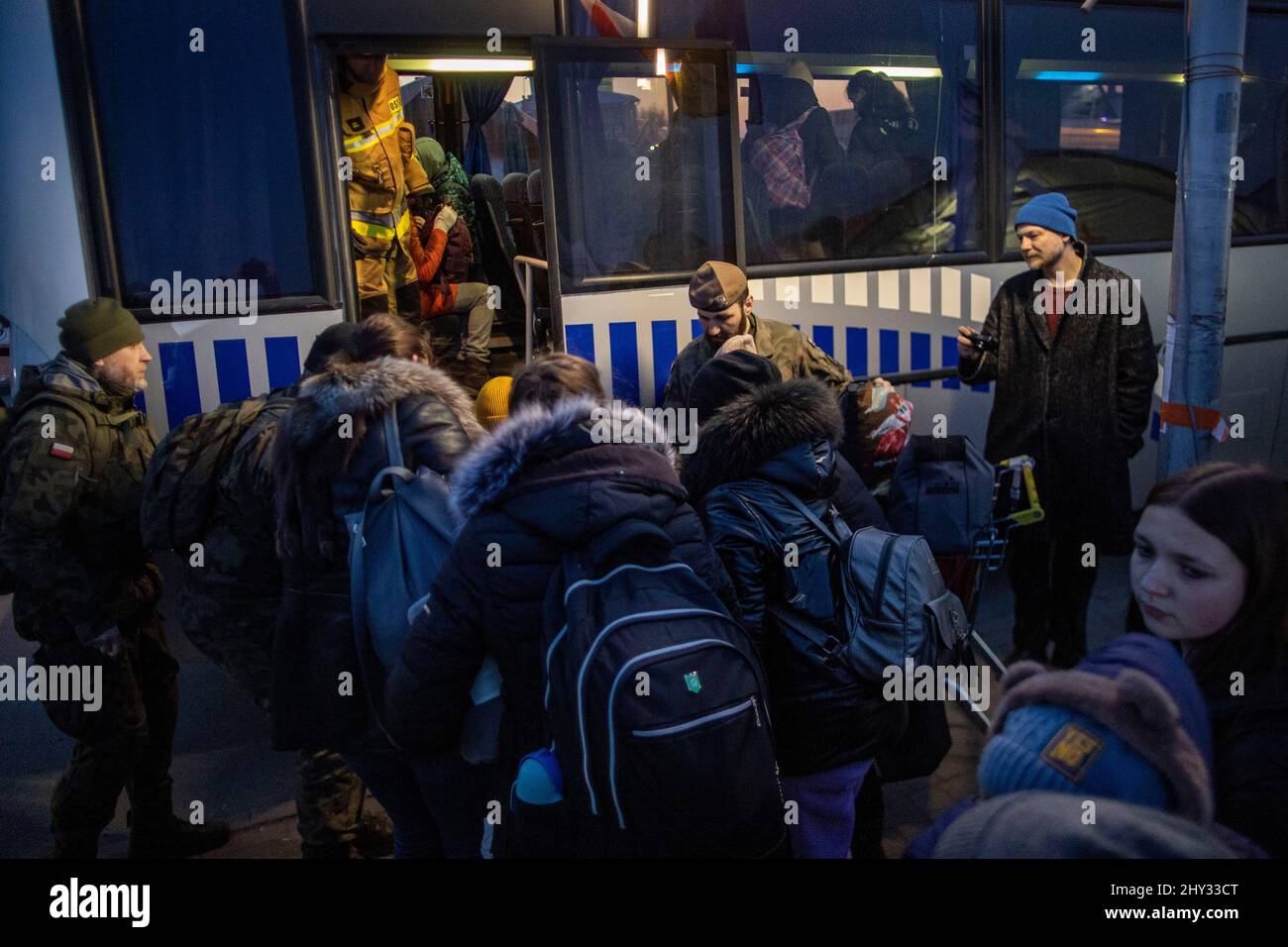 Przemysl, Poland. 14th Mar, 2022. Refugees from Ukraine board a bus ...