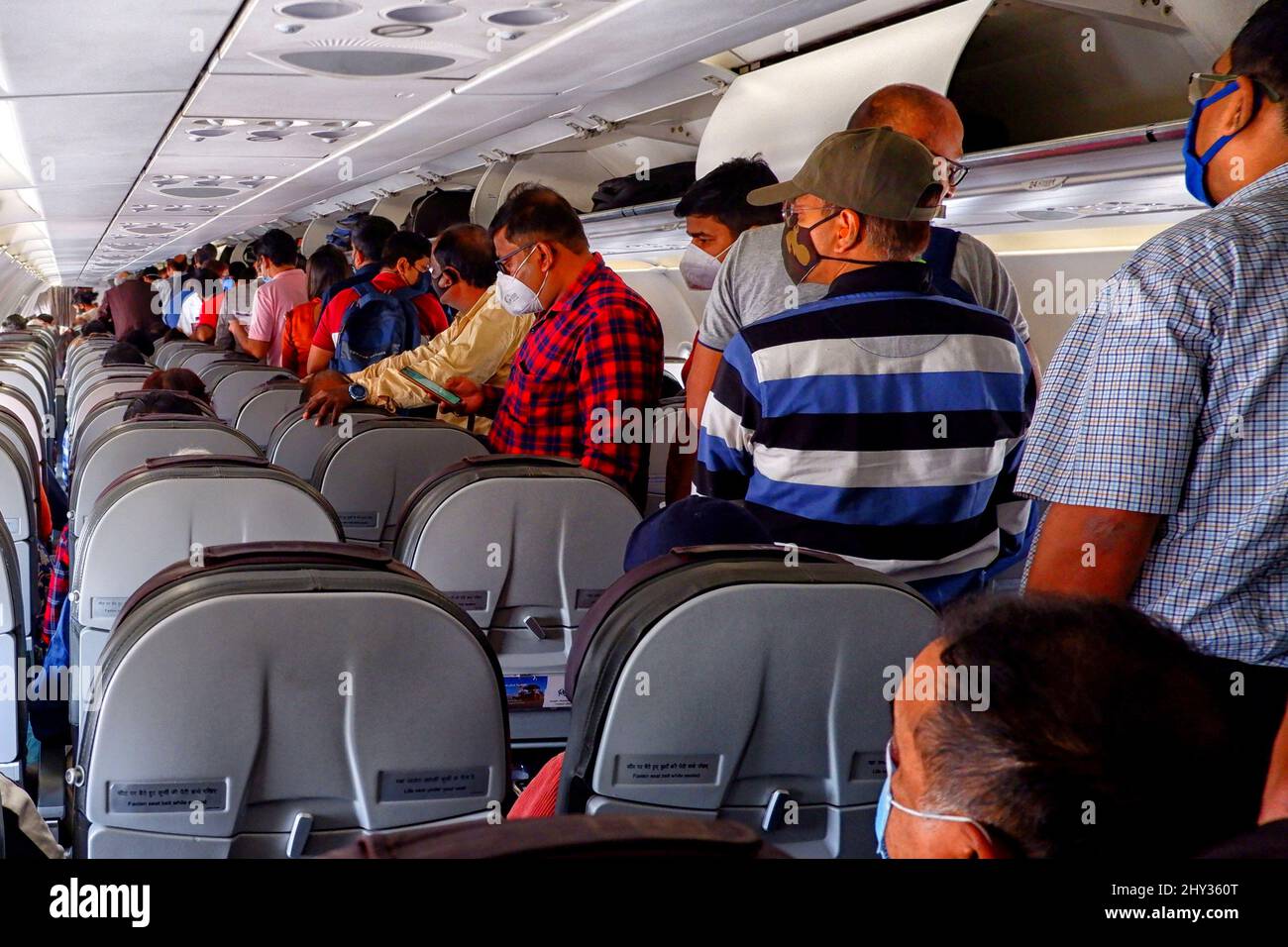 Travellers seen standing while waiting for the cabin crew's ...