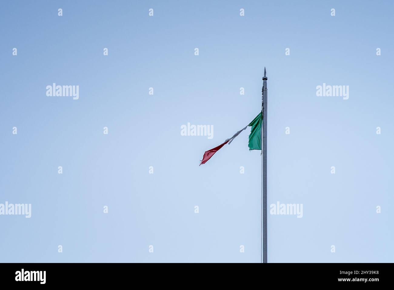 View of the italian flag torn apart hanging from a pole and waving in ...