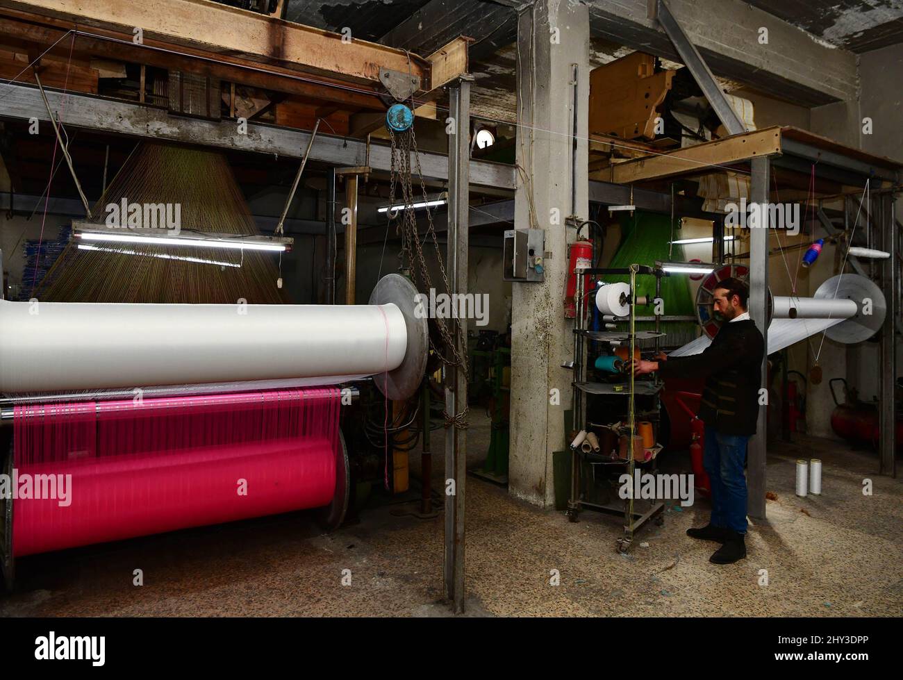 Aleppo. 7th Mar, 2022. A Syrian man works at a textile workshop at the ...