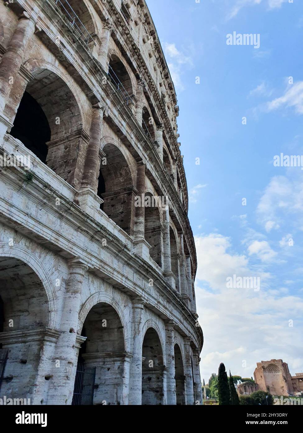 Vertical shot of the Colosseum building under the blue sunny sky, Rome ...