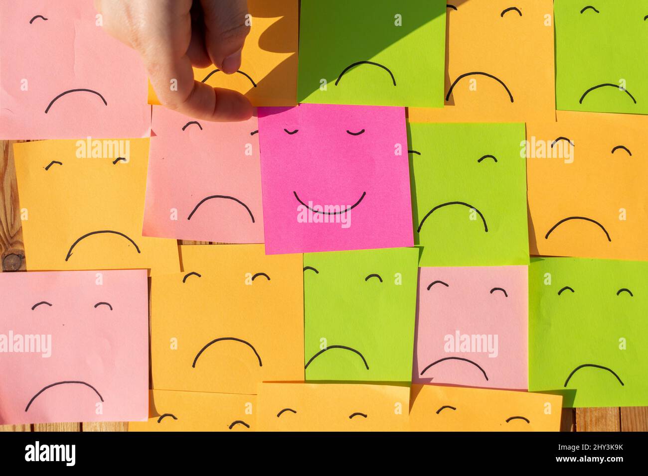 Closeup shot of many colorful office notes with many sad and one happy ...
