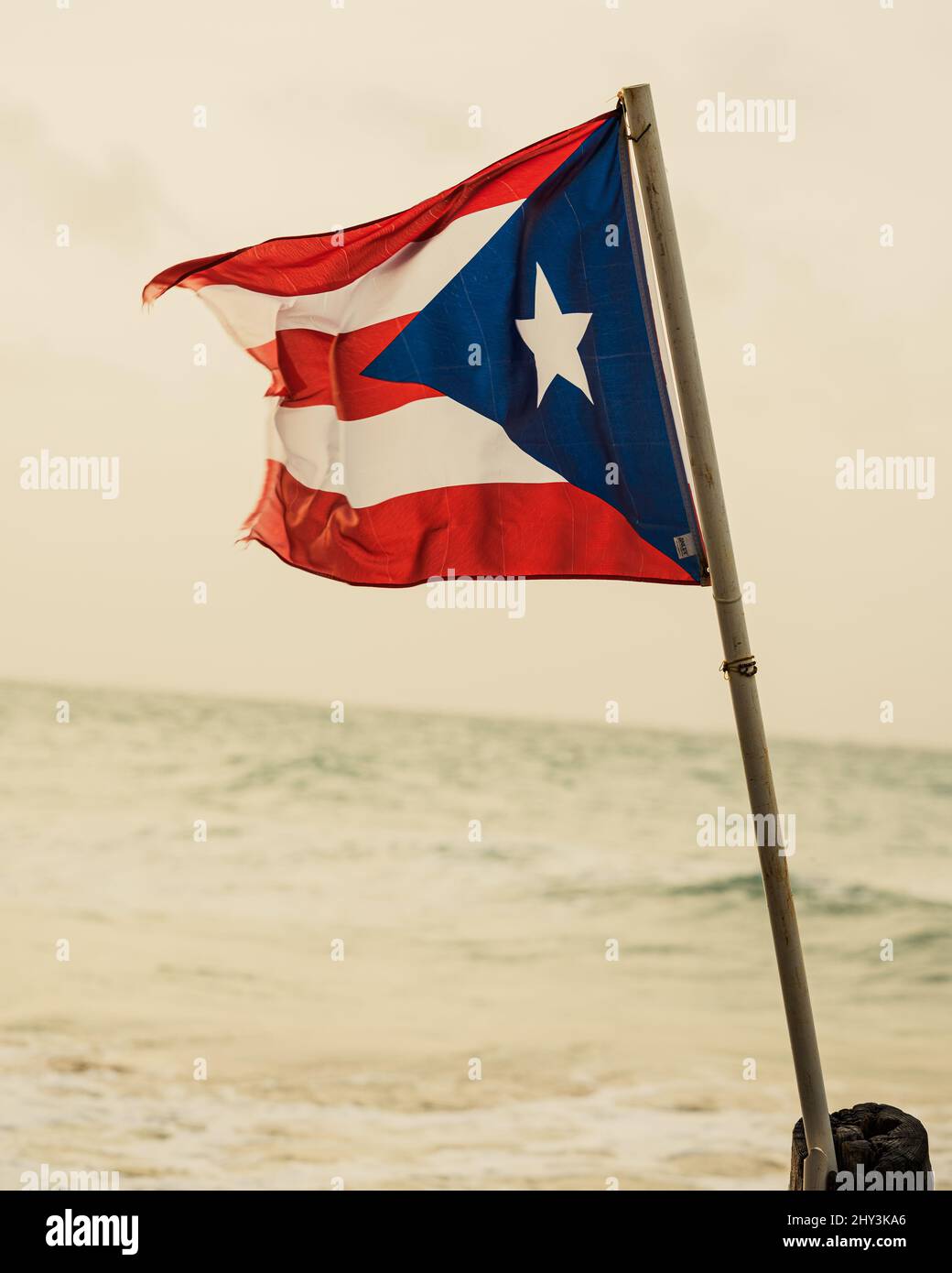 Selective of a flag of Puerto Rico against the sea on a gloomy day ...