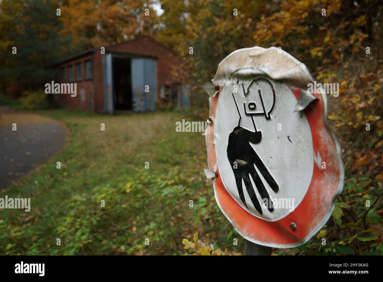 Closeup shot of the broken sign with building and trees on the blurry ...