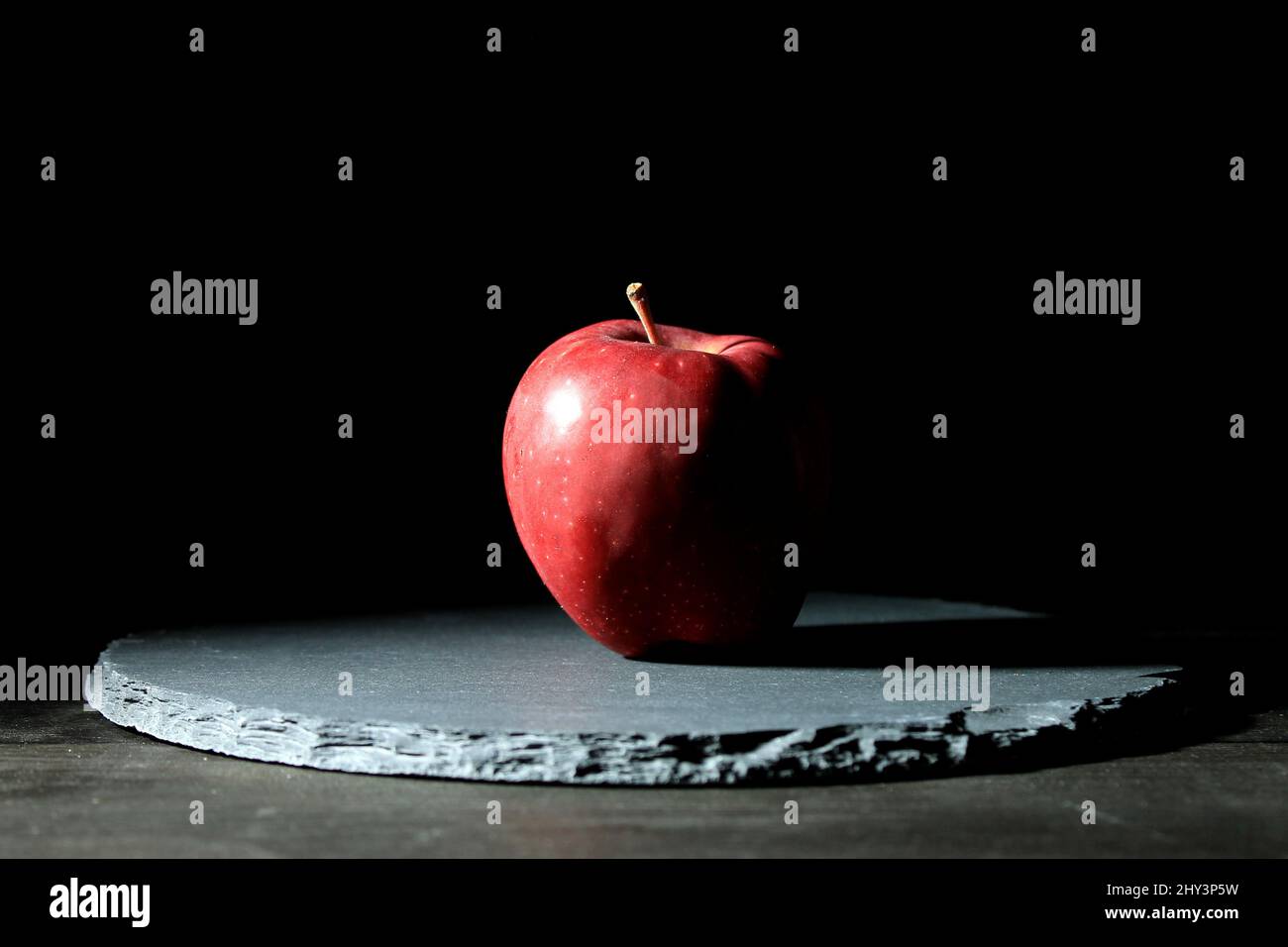Closeup of a red apple half in a shadow on a slate plate Stock Photo ...