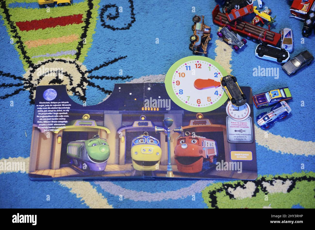 Open child books with trains and a clock on a floor Stock Photo - Alamy