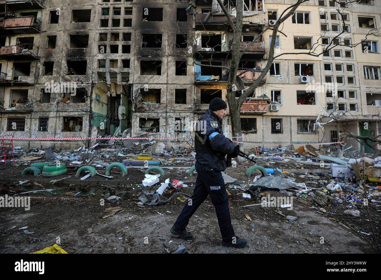The policeman walks by an apartment building that was shelled by the ...