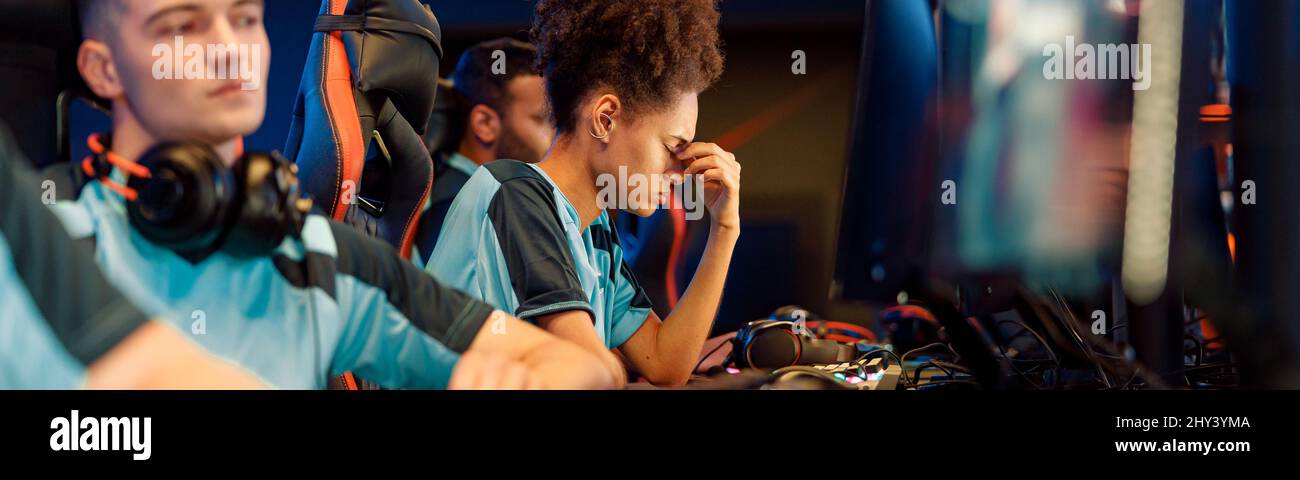 Young woman gamer feeling depressed while playing in cyber club Stock ...