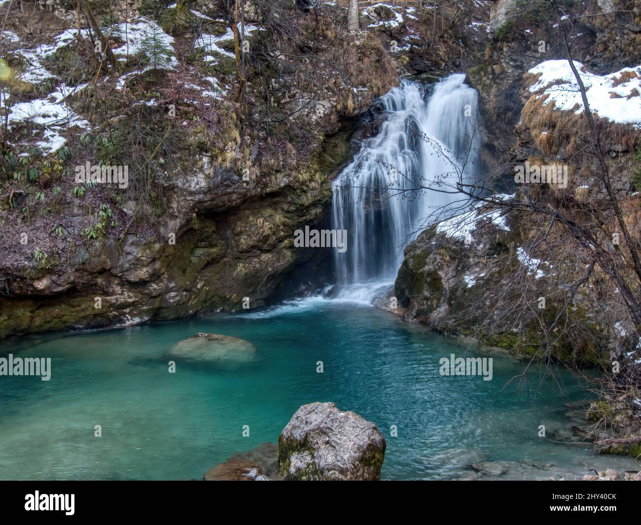 Beautiful waterfall in the forest with rocks covered with snow Stock ...