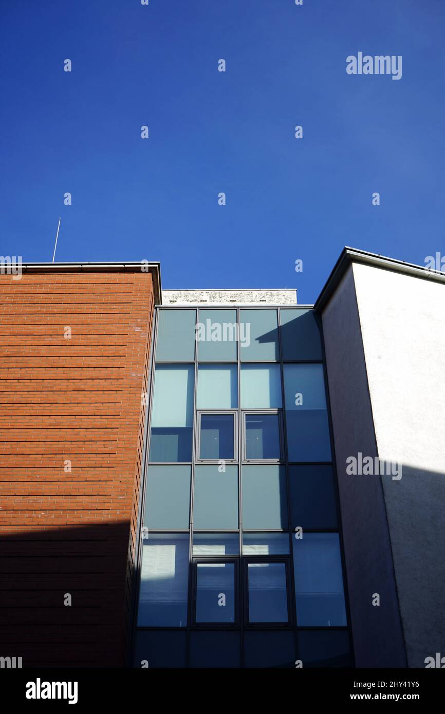 Low angle of a modern glass-walled building under a clear blue sky ...