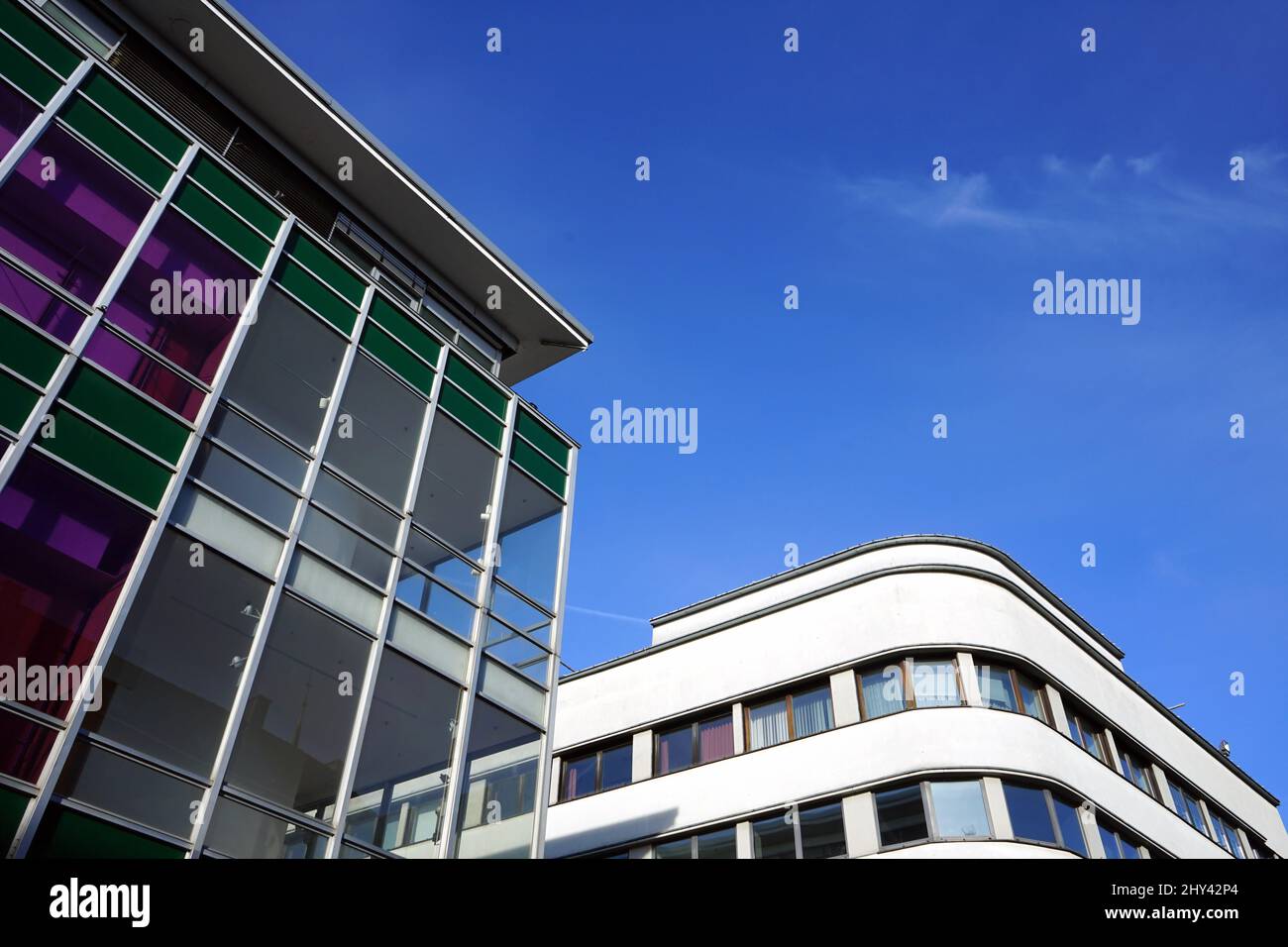 Low angle of a modern glass-walled building under a clear blue sky ...