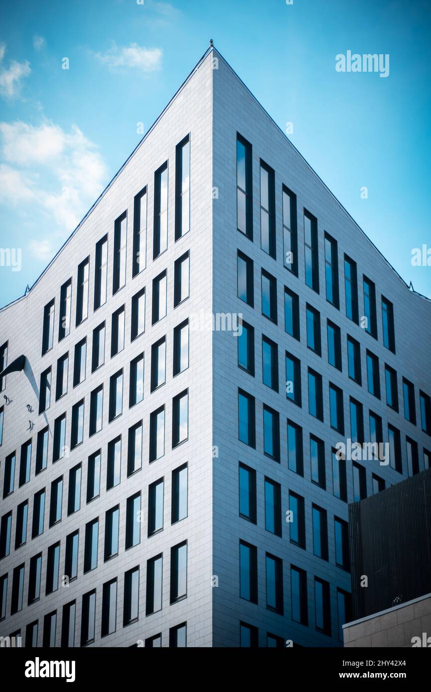 Facade of a modern building with a simple angular design against a blue ...