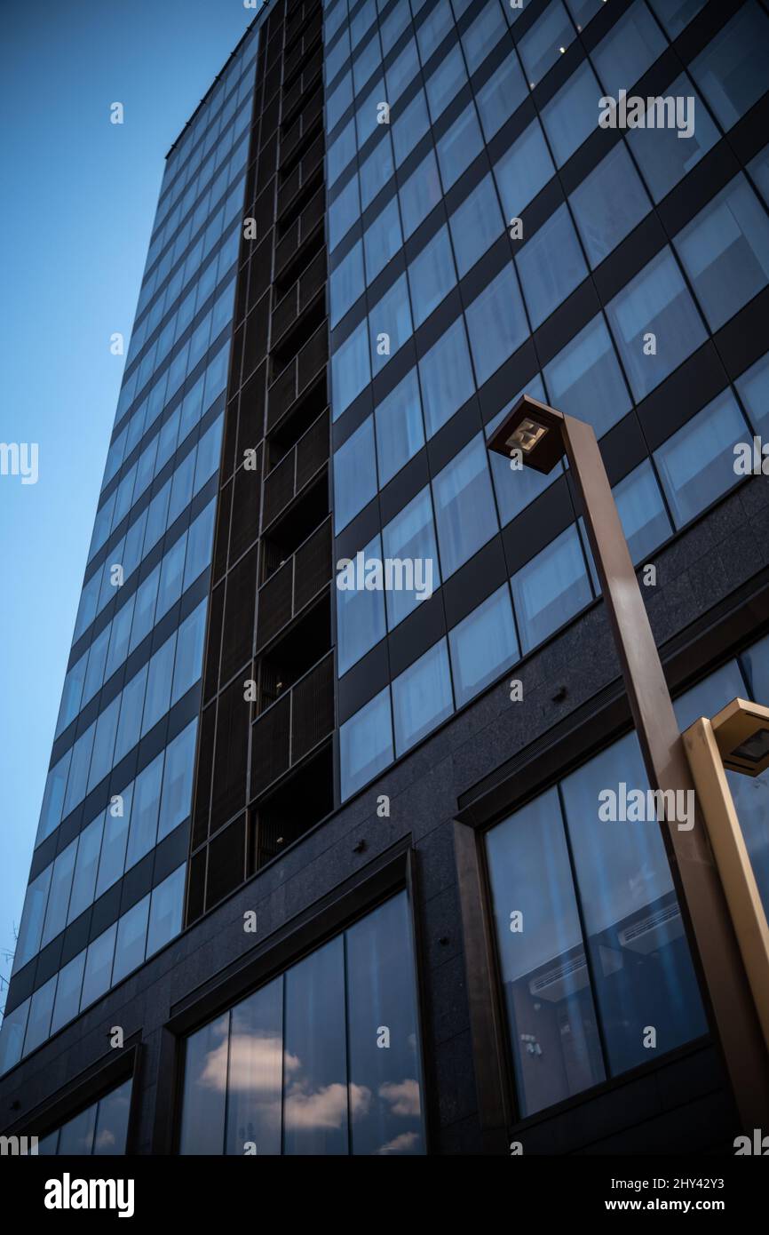 Exterior view of a modern building with glass windows against a blue ...