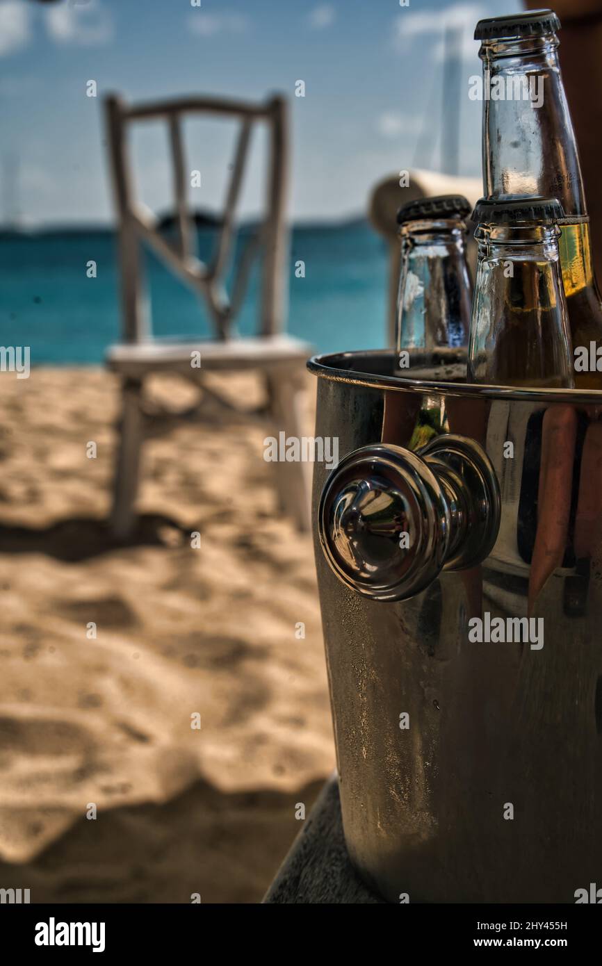 Close-up of a bucket with cold beers on the sandy beach of Canouan ...