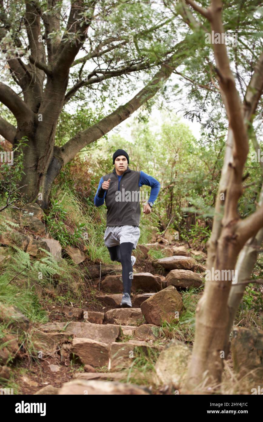 All roads lead to fitness. A young man running outdoors Stock Photo - Alamy