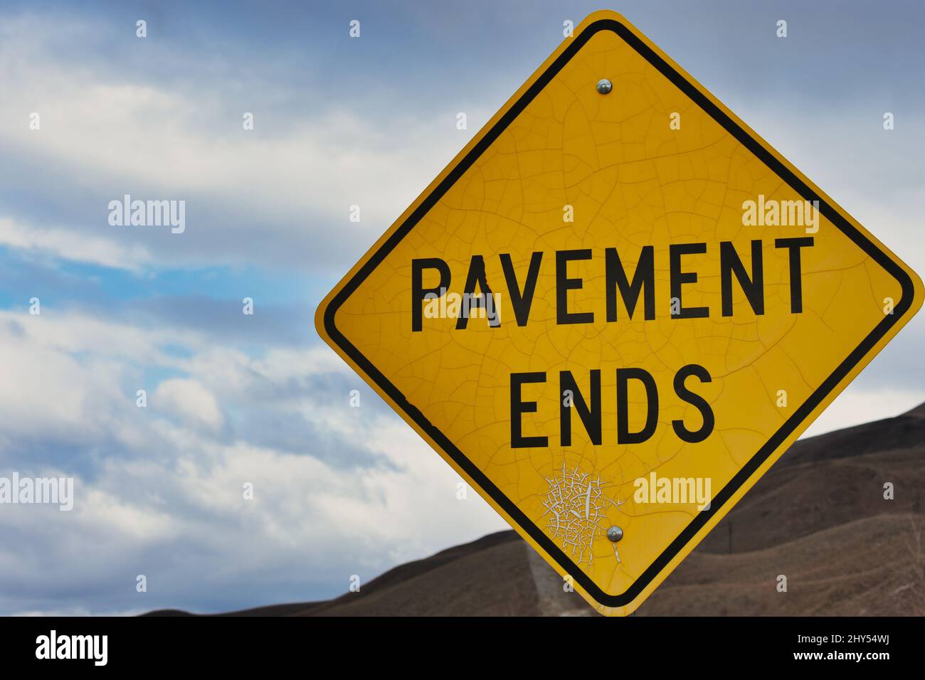 Closeup shot of the yellow "pavement ends" warning sign with bullet ...
