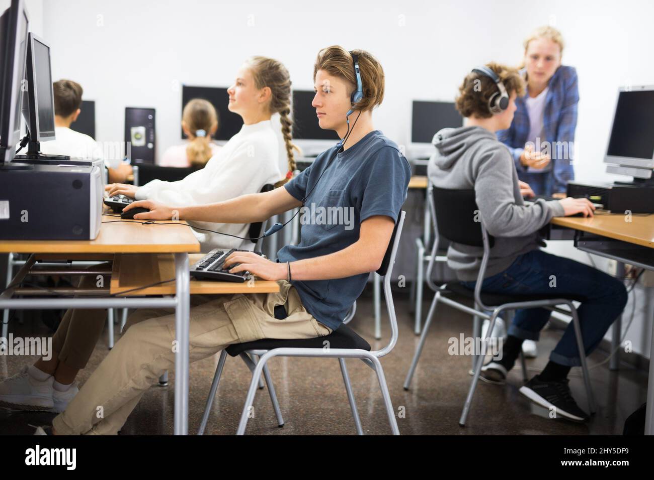 Teenage student in headphones at the computer in school class Stock ...