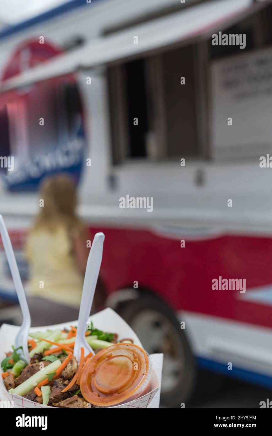 Blurry food truck background with paper food tray of chicken teriyaki ...