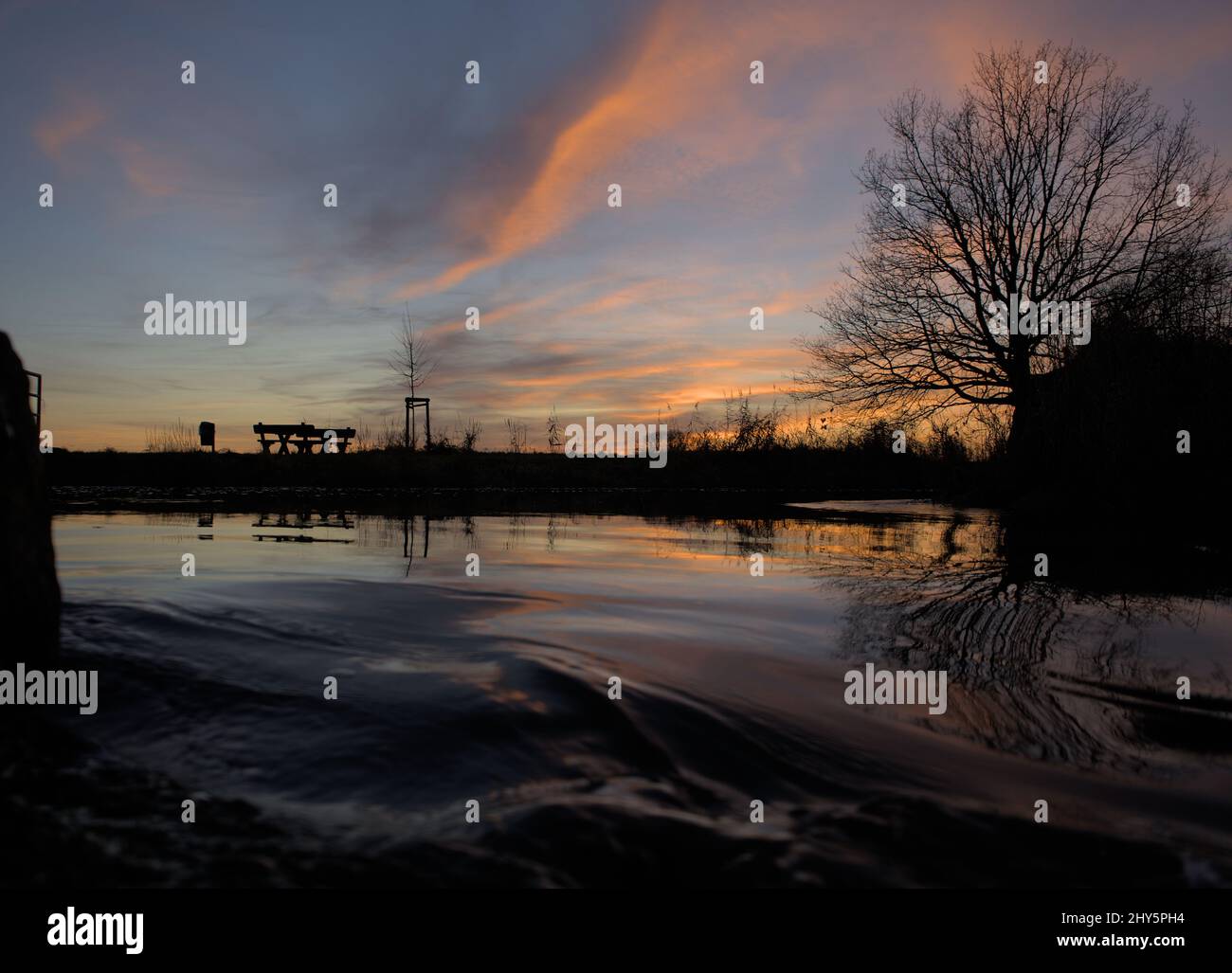 View of a river with sunset reflection Stock Photo - Alamy