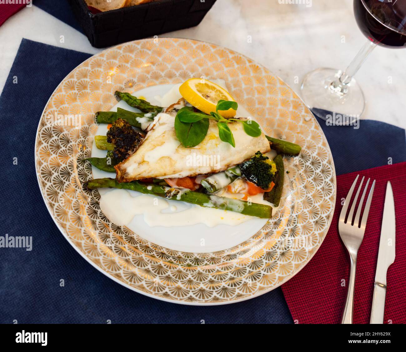 Baked dorada fillet with vegetable garnish and creamy sauce Stock Photo ...