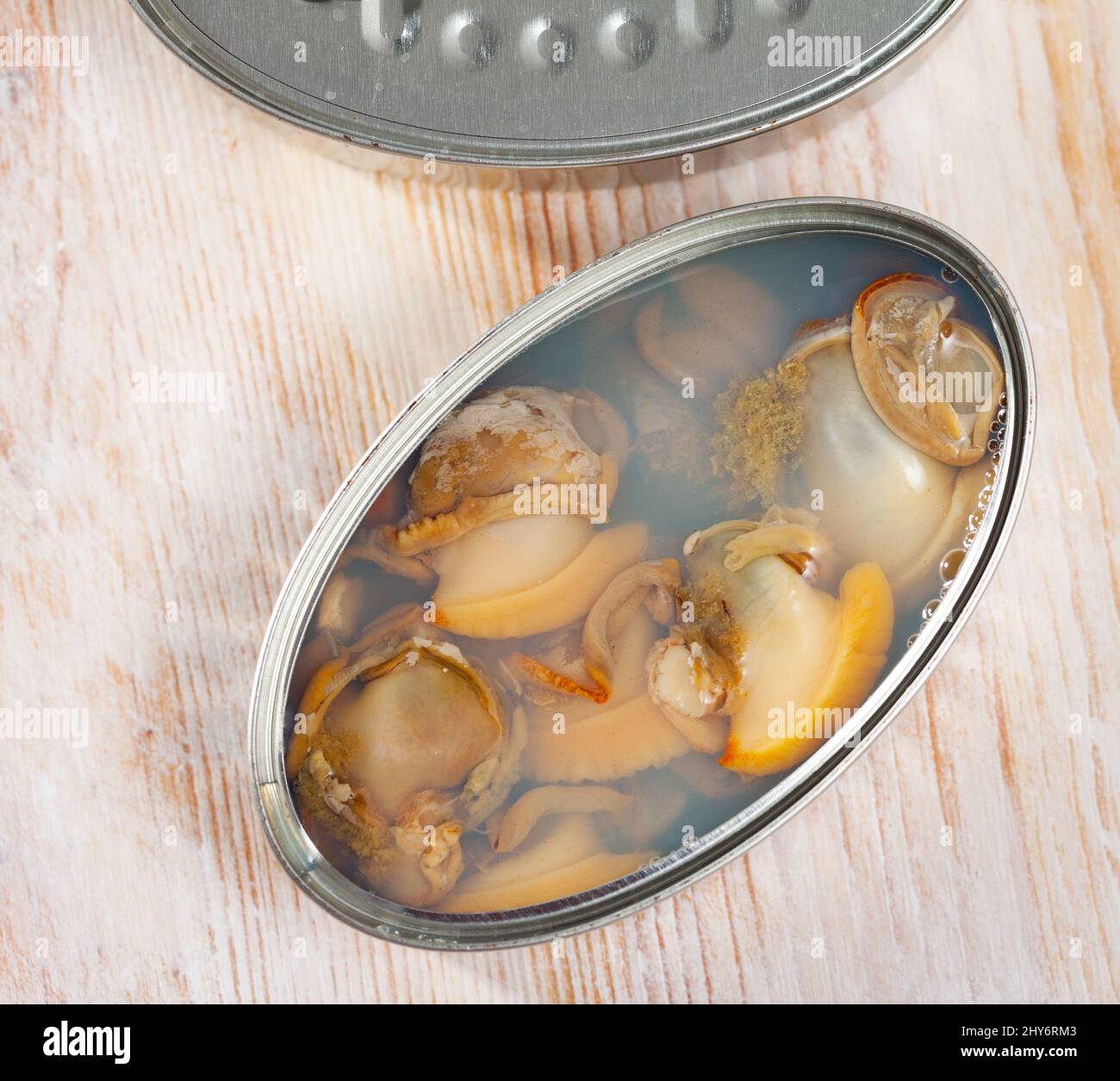 Marinated shellfish in an open tin can on wooden table Stock Photo - Alamy
