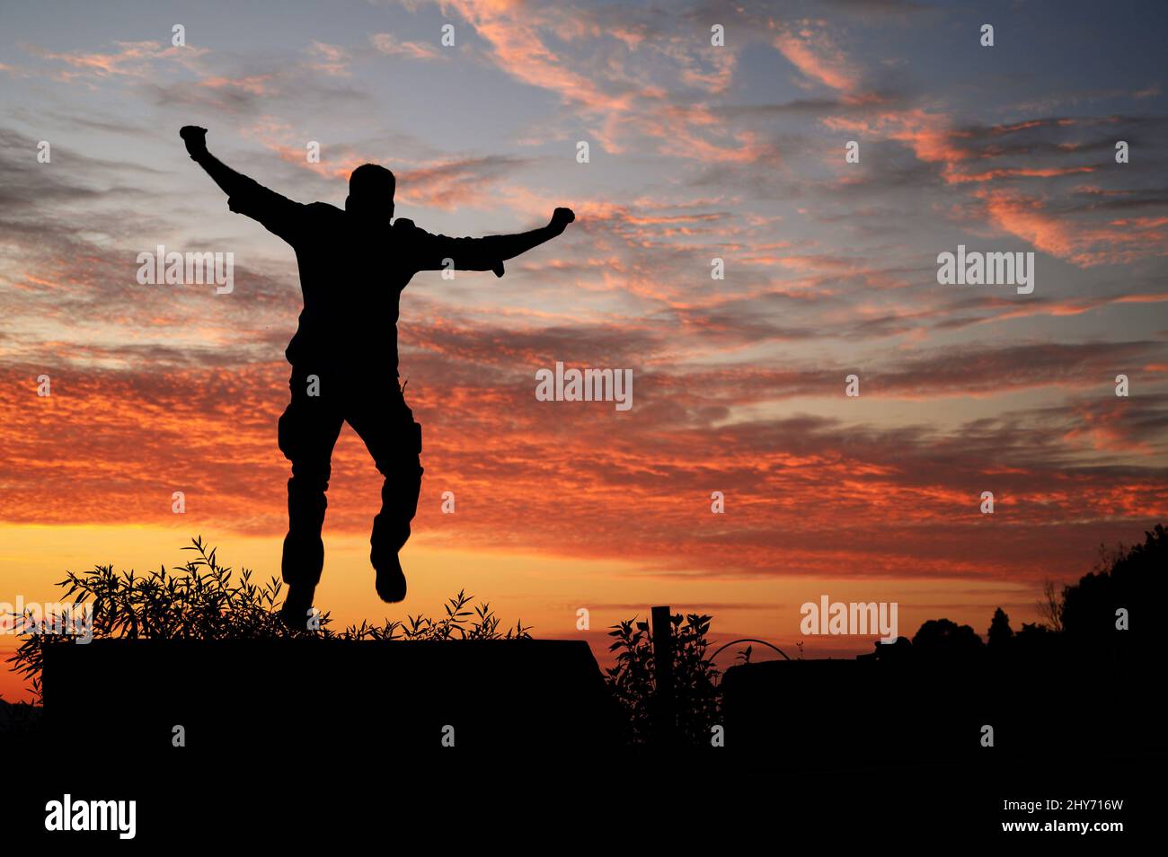 Silhouette of a man jumping in the sunset Stock Photo - Alamy