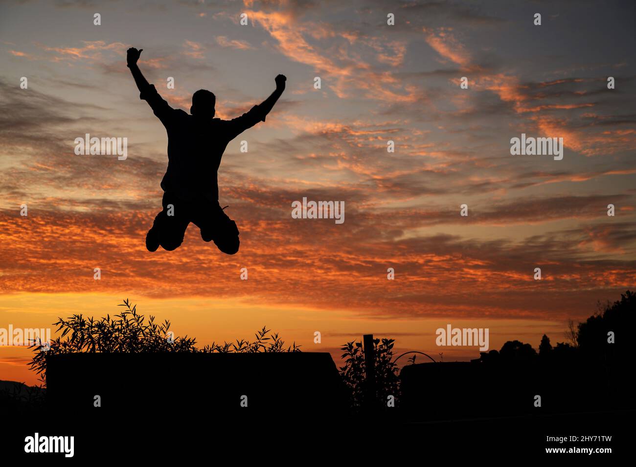 Silhouette of a man jumping in the sunset Stock Photo - Alamy