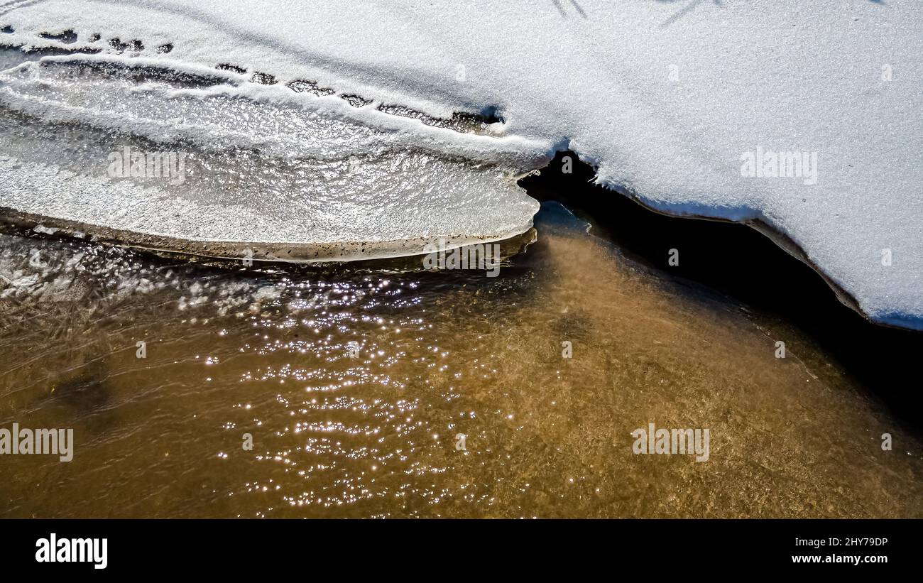 A small stream with ice and snow melting creating moving water Stock ...