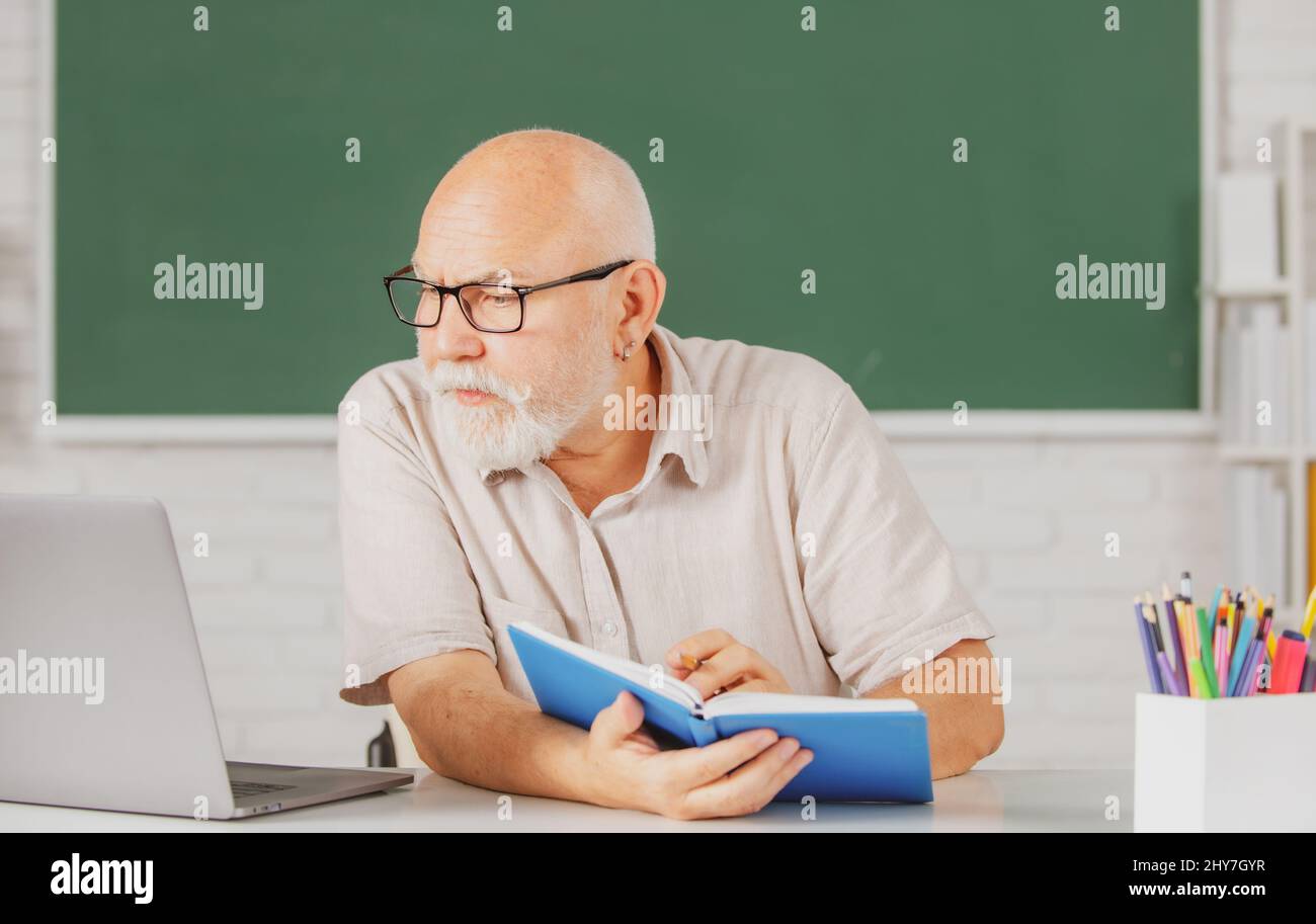 Portrait of confident caucasian senior teacher in classroom. Adult ...
