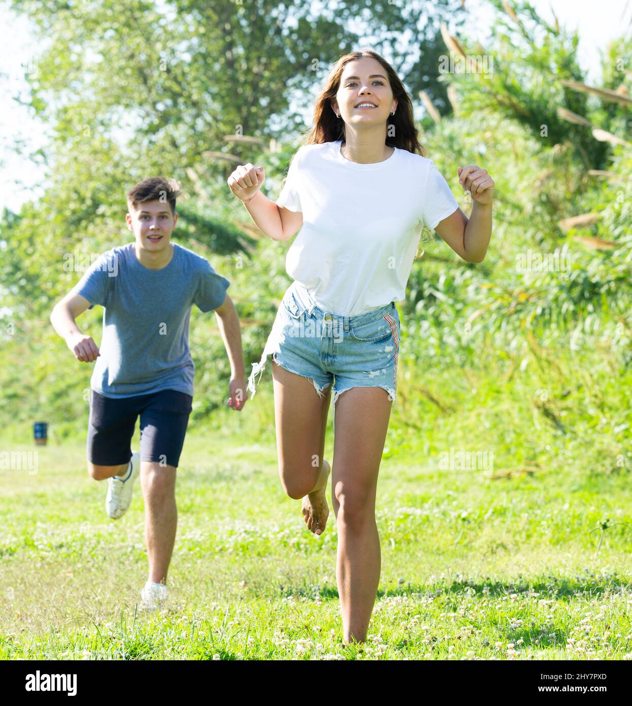 Cheerful teenagers are jogging together in park and having fun Stock ...