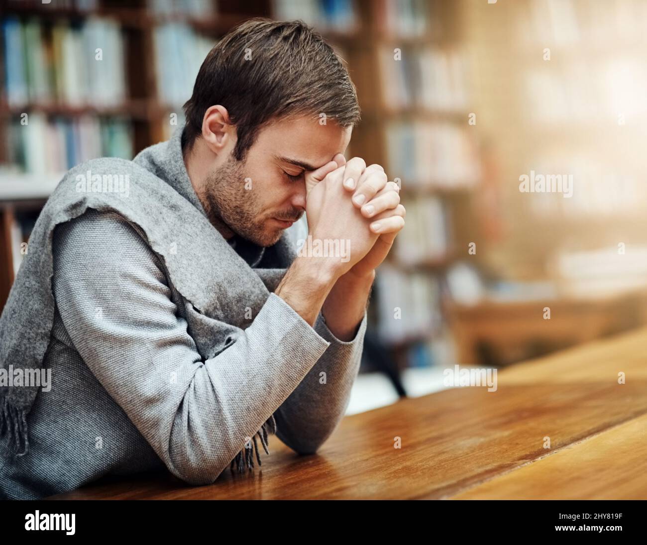 Seeking help from above. Cropped shot of a handsome young man praying ...