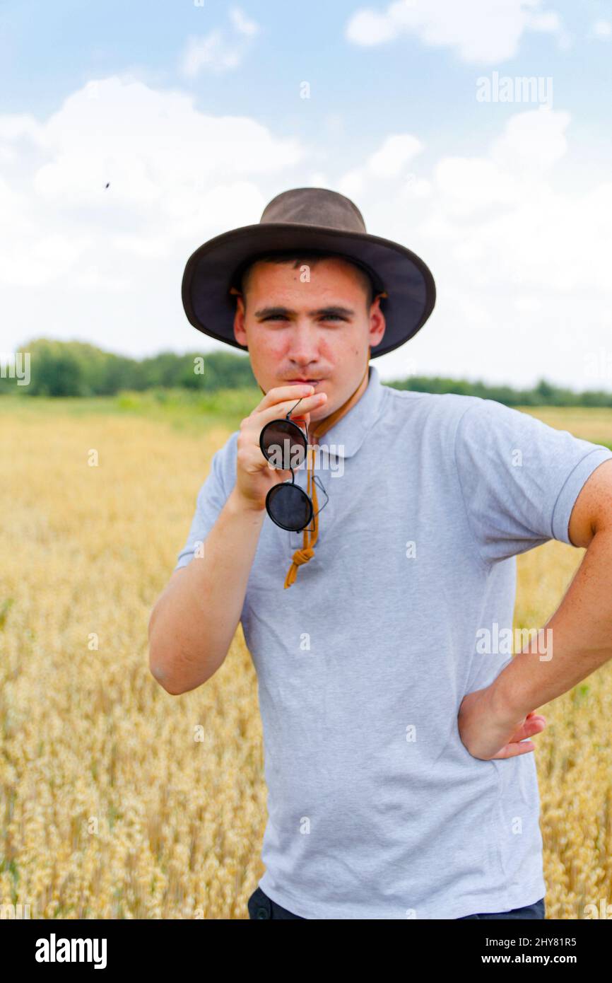 Man wear sunglasses. Portrait of farmer standing in gold wheat field ...