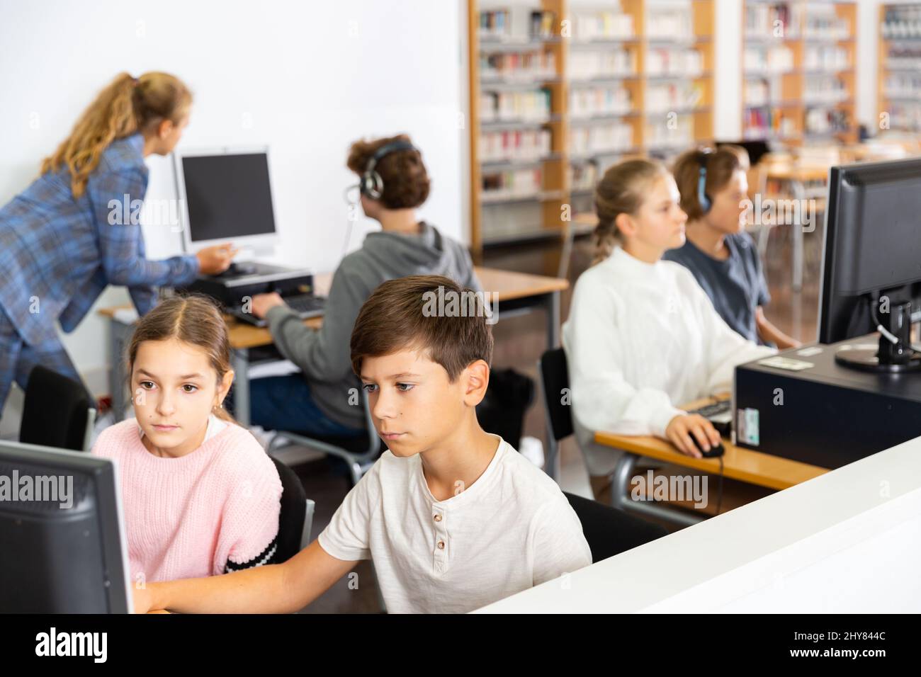 Preteen boy and girl learn to solve problems on computer in school classroom Stock Photo - Alamy