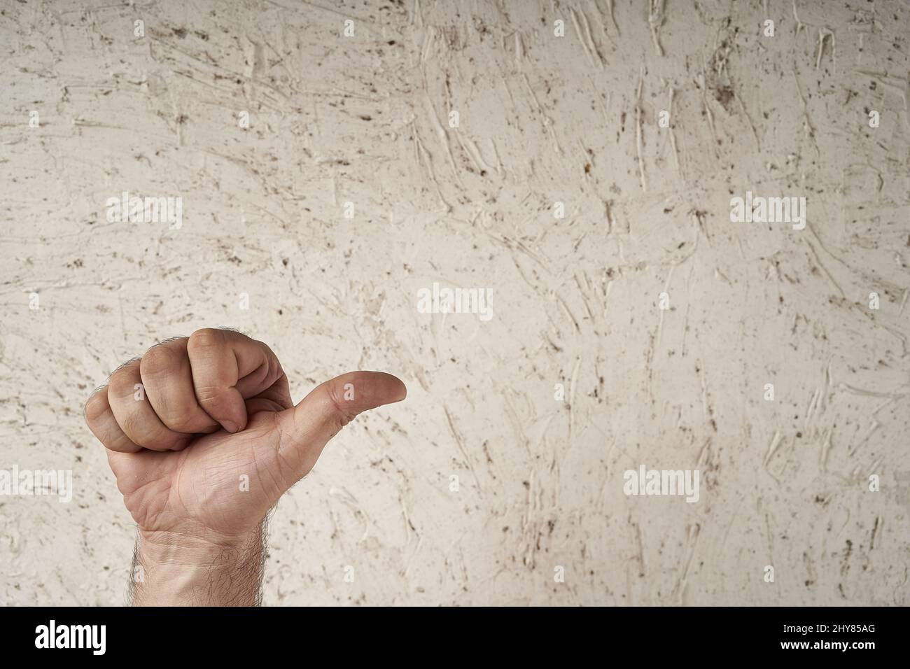 Closeup of man hand pointing thumb to the right or up vertically with ...