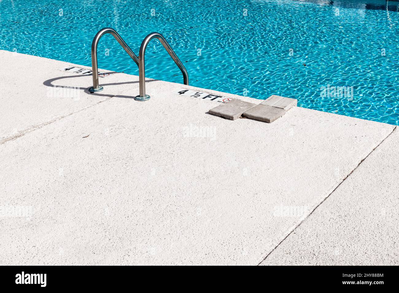 Empty outdoor swimming pool with a ladder on a sunny day Stock Photo ...