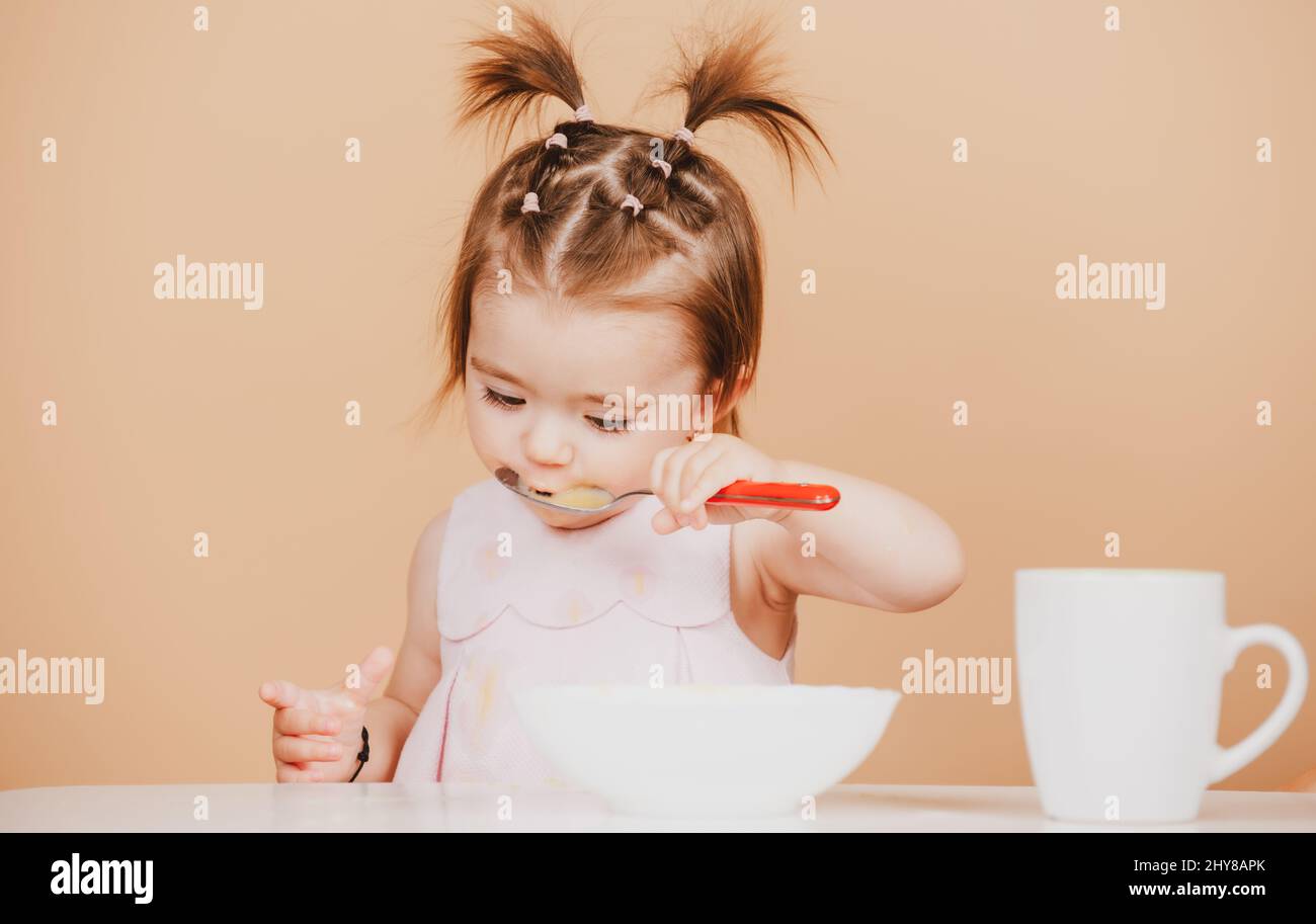Kid eat healthy nutrition, baby food. Babies eating with spoon. Lick ...