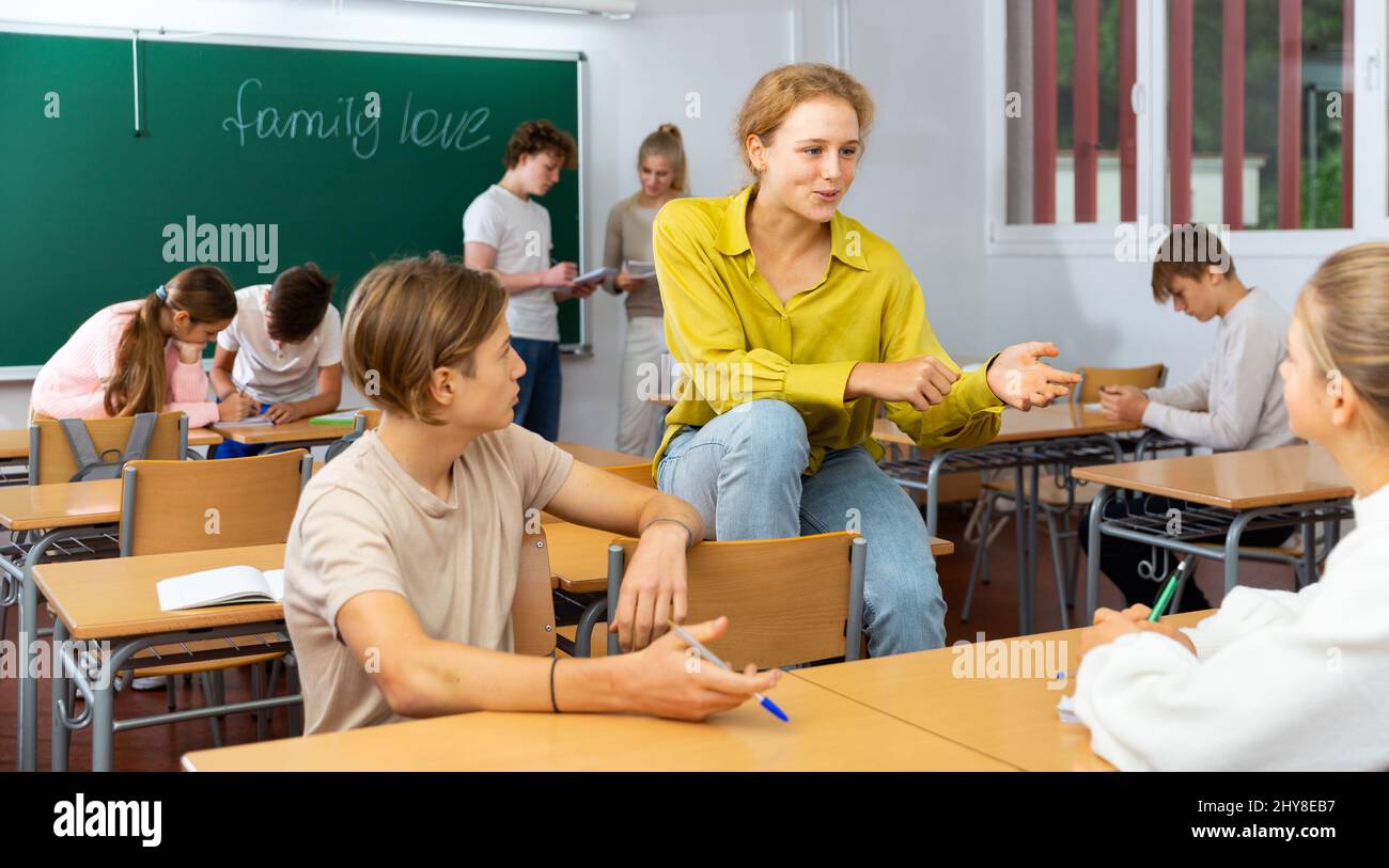 Teenagers resting and talking during recess in classroom Stock Photo ...