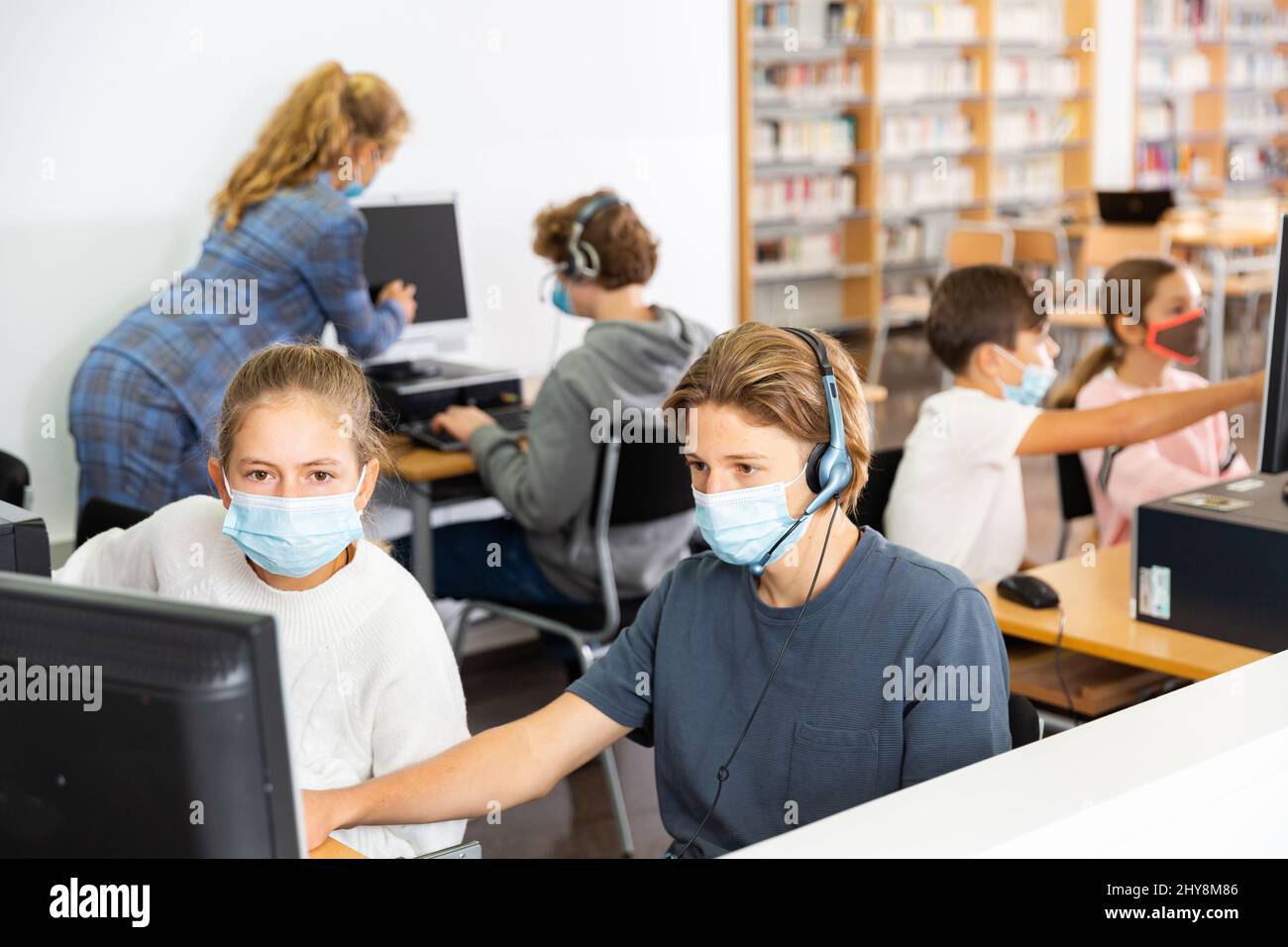 Teenagers wearing masks in computer class in library Stock Photo - Alamy