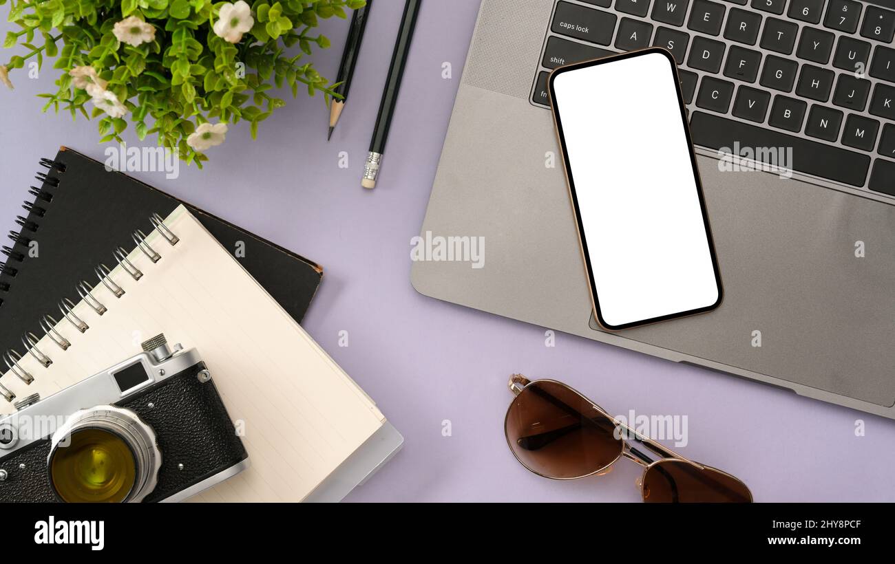 Trendy modern workspace with laptop computer, diary, camera, sunglasses ...