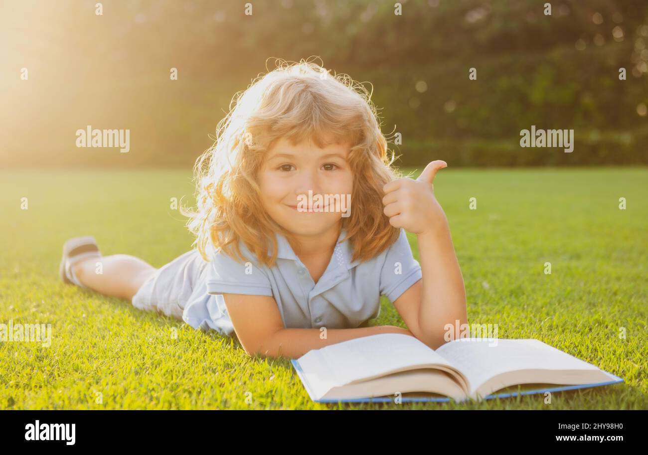 Kid read book. Child school with thumbs up and outdoor education ...