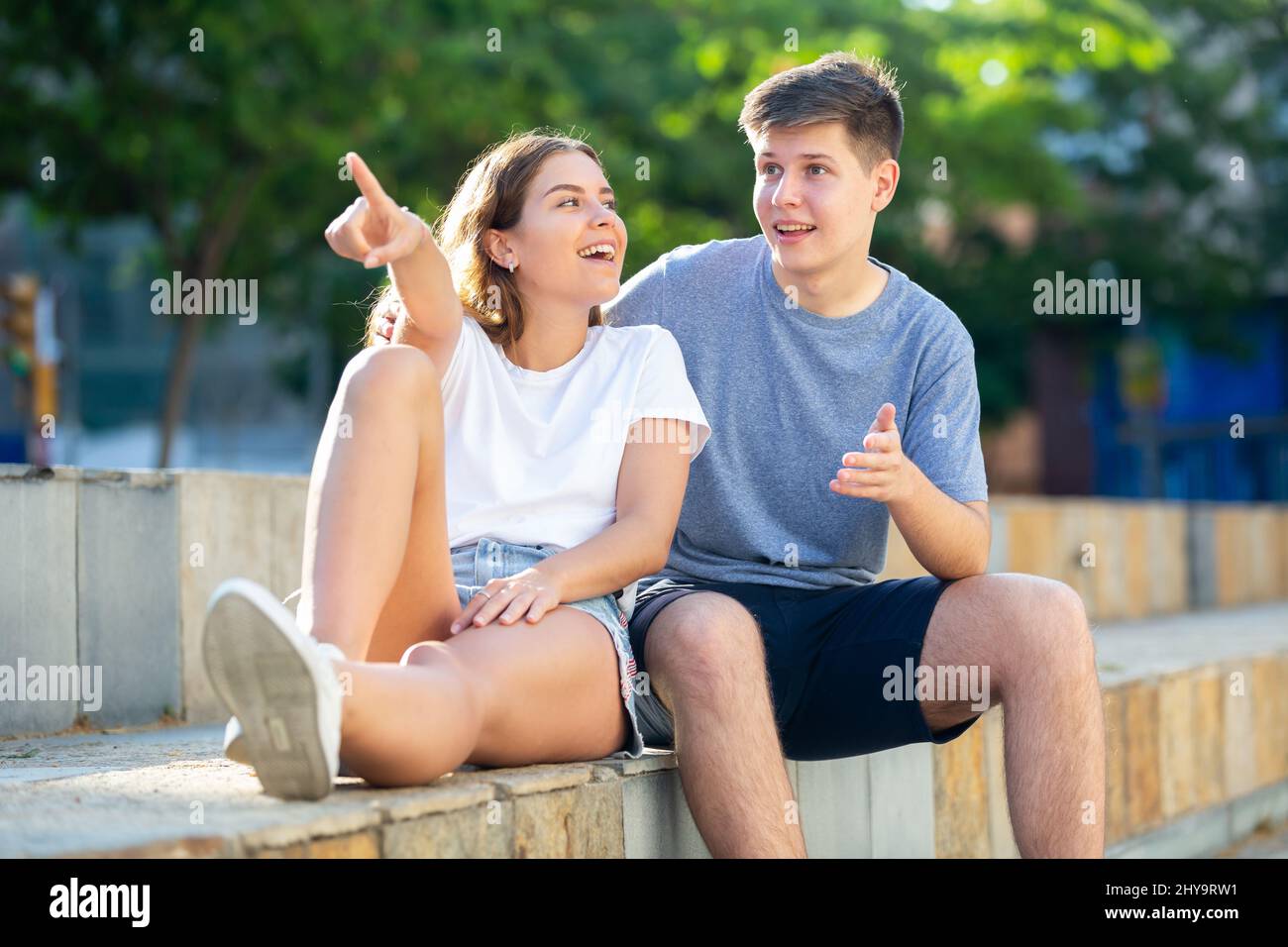 Girl prompts the boy, pointing with his hand at something Stock Photo ...