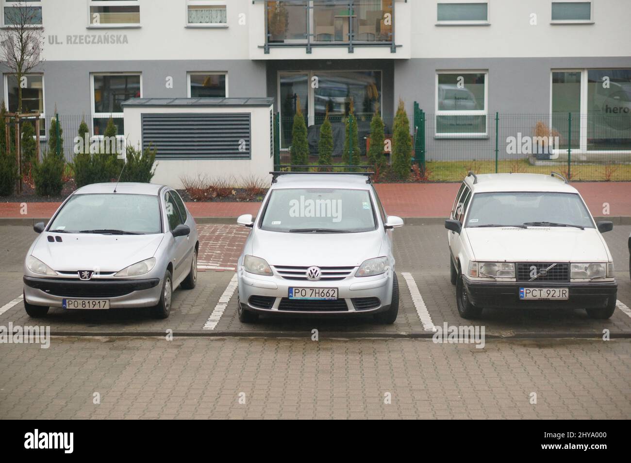 Three Volvo, Volkswagen, and Peugeot cars on parking places by an ...