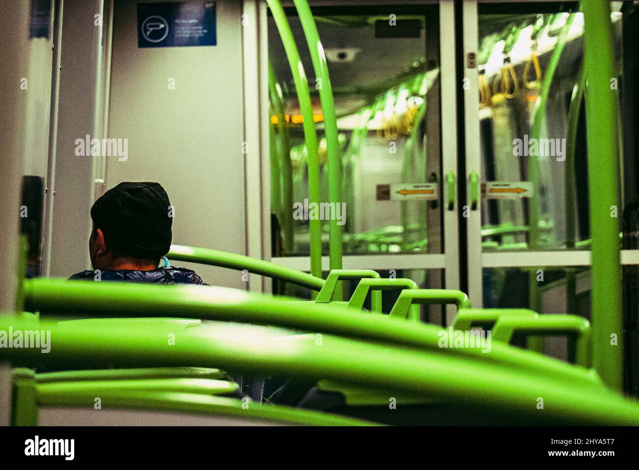 Back view of a head of a male passenger sitting in a bus, the green ...