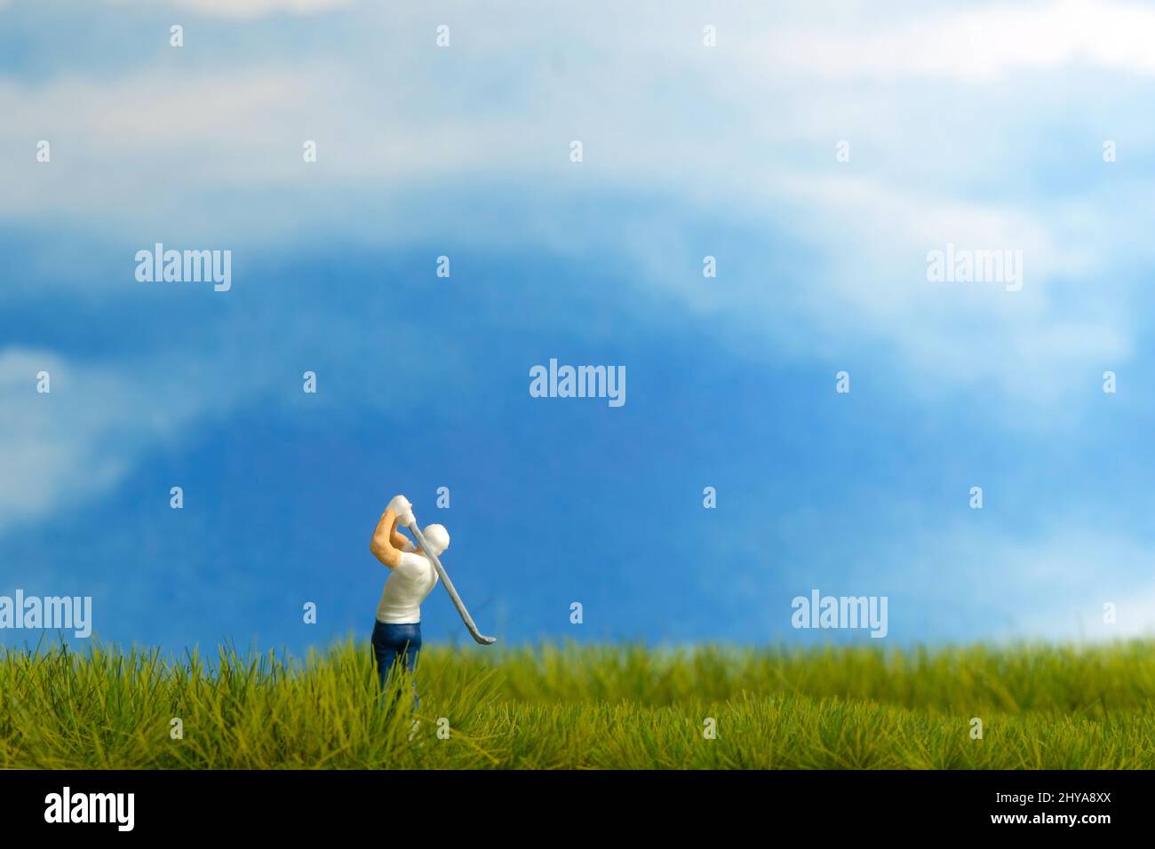 Miniature people toy figure photography. A men golfer doing golf drive ...