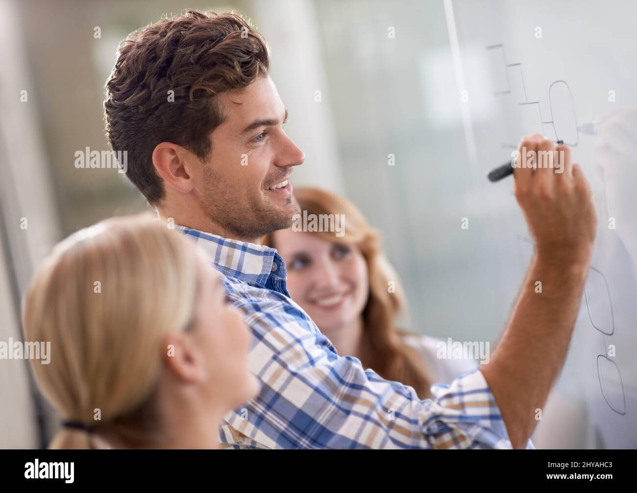 Brainstorming together. A handsome young businessman brainstorming with ...