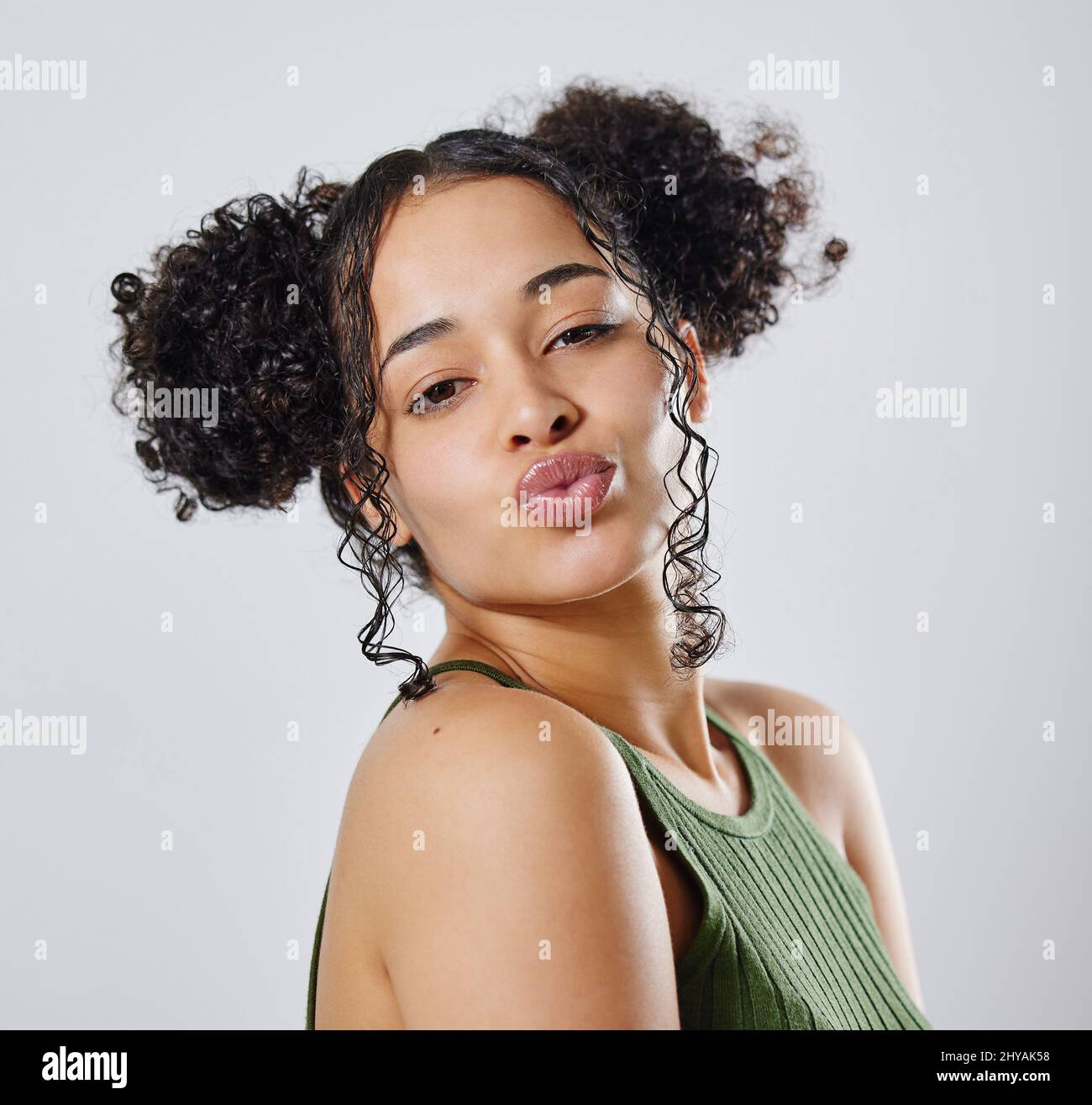 This is my favourite look. Shot of a woman with two buns posing against ...