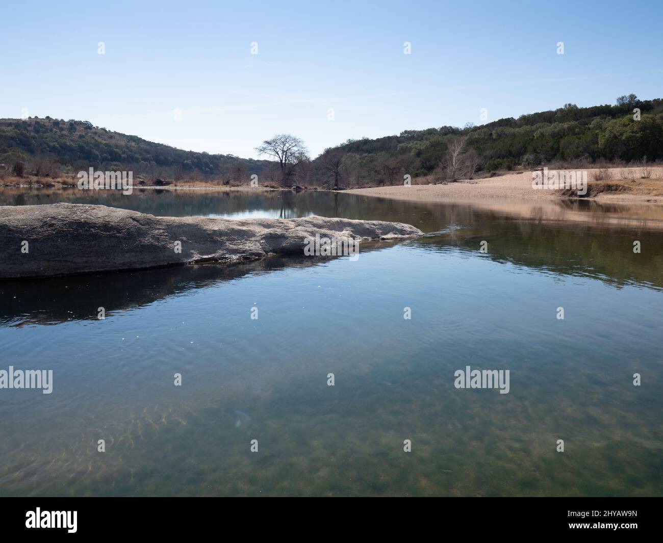 Pool of clear water in the Pedernales River with a sandy beach and ...