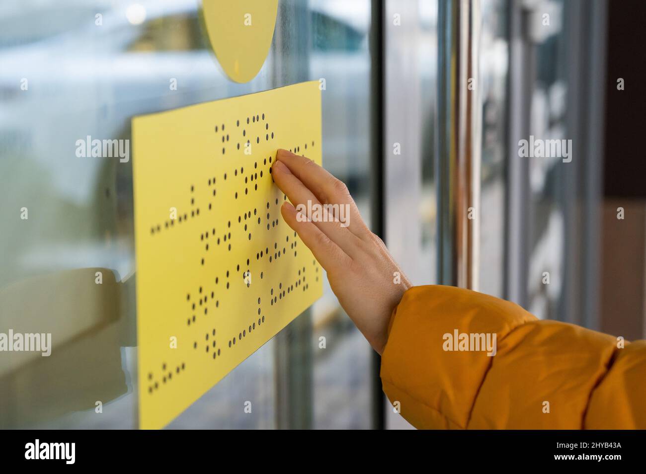 Close-up of a woman reading a braille lettering on a glass door Stock ...